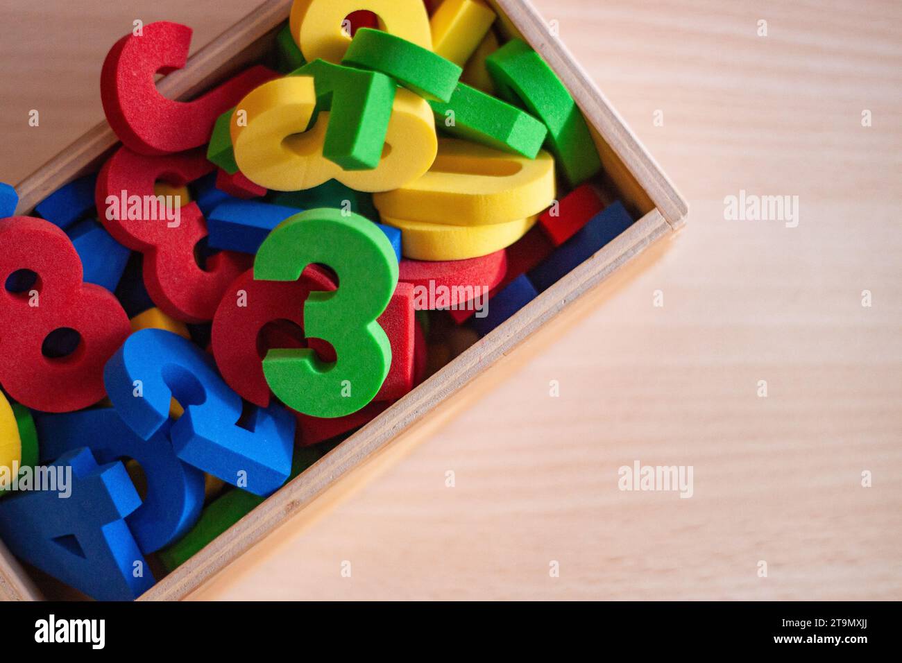 wooden box filled with colorful numbers, used for children learning ...