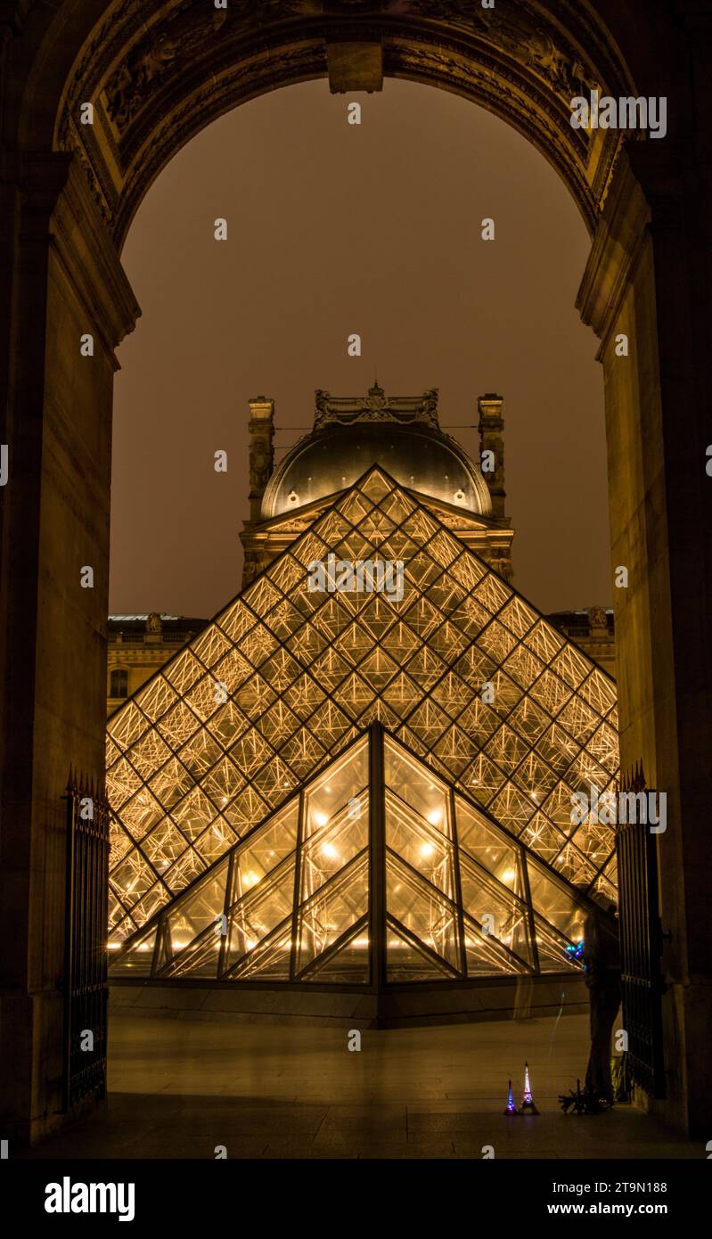 A young man standing in front of the iconic glass pyramids of the ...