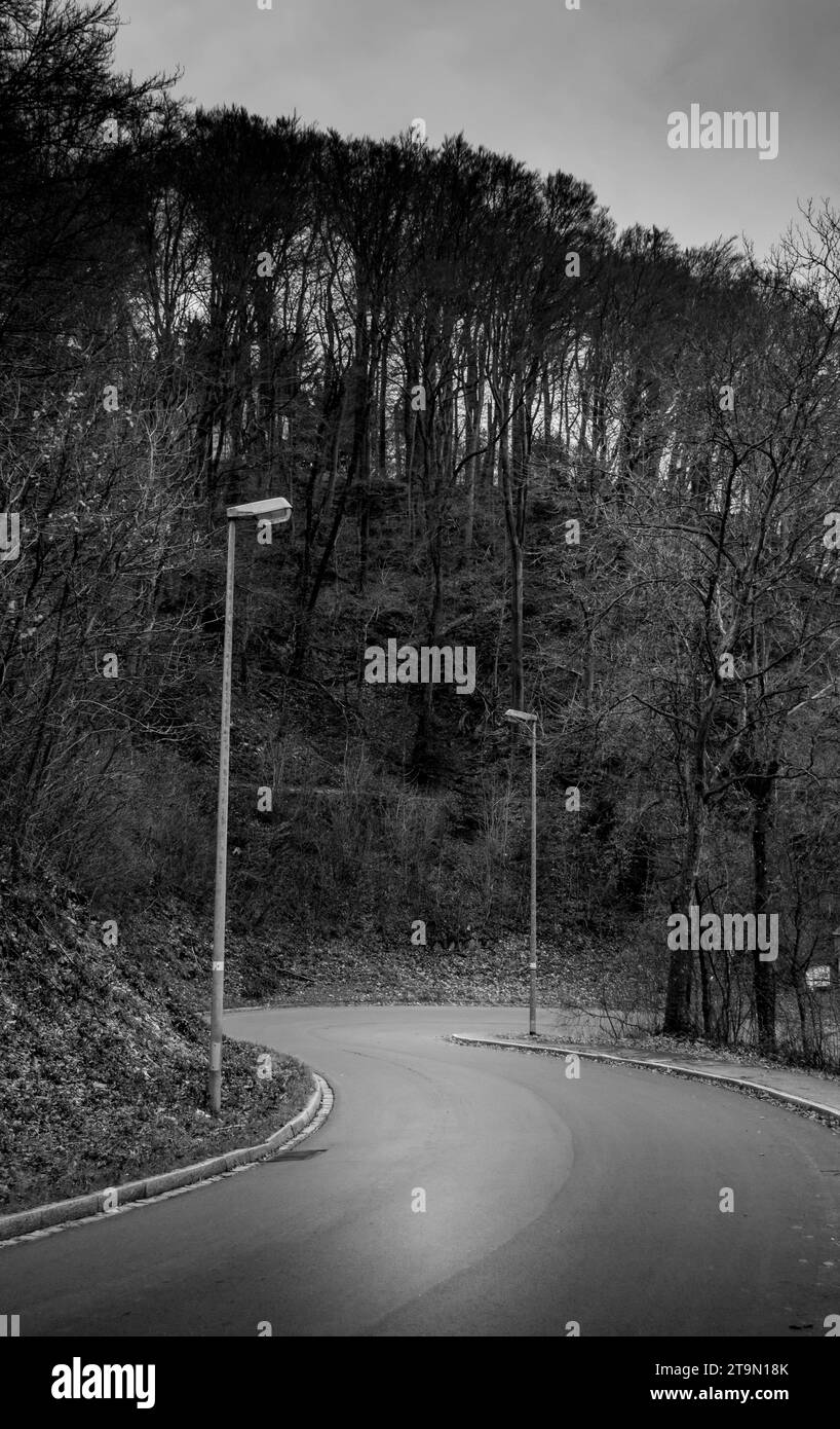 A winding, asphalt road curves its way up to the summit of a steep hill ...