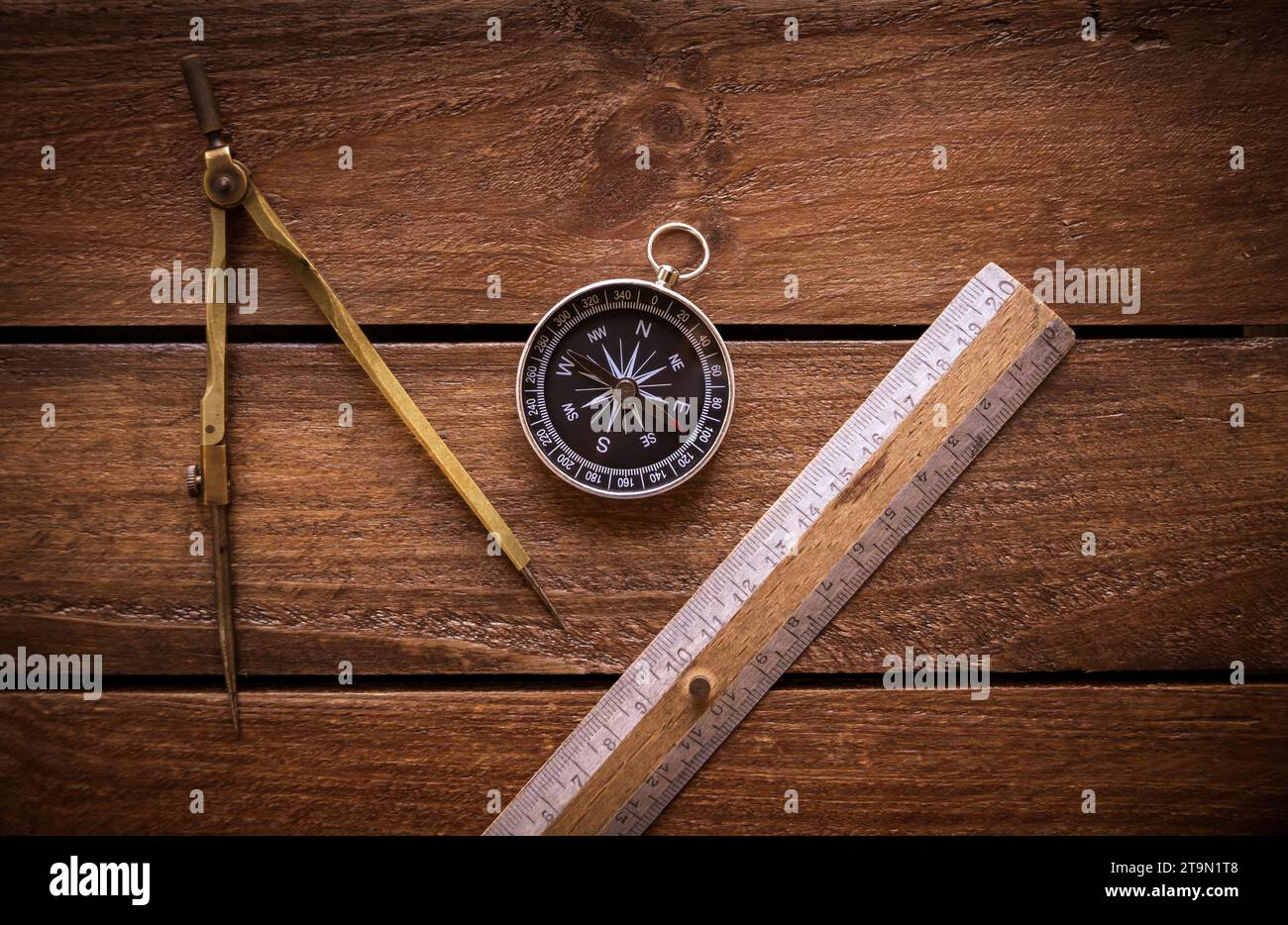 Vintage ruler, drawing and navigational Compass on a rustic wooden ...