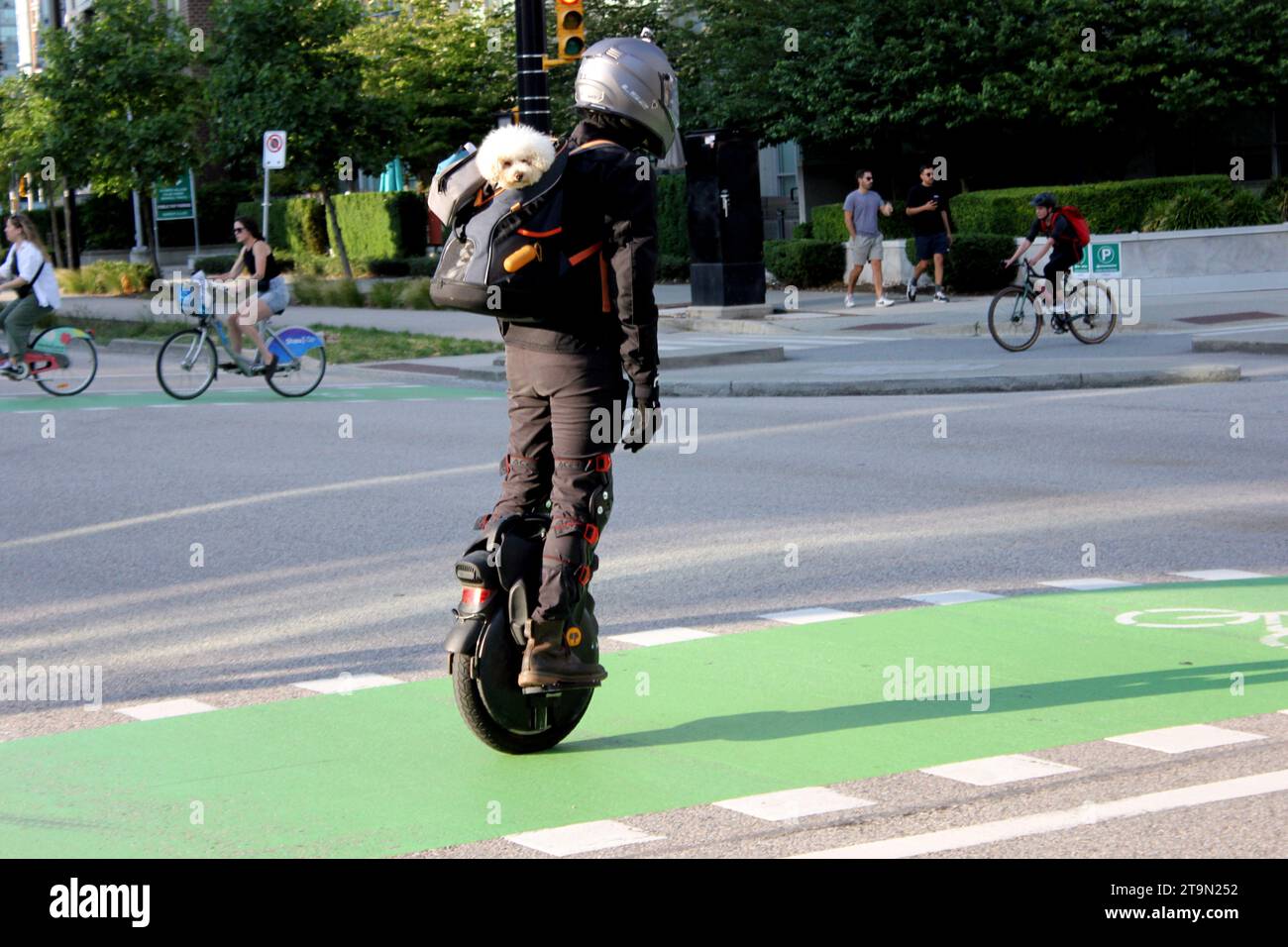 A stylish motorcyclist stands at an intersection, wearing a full-body ...