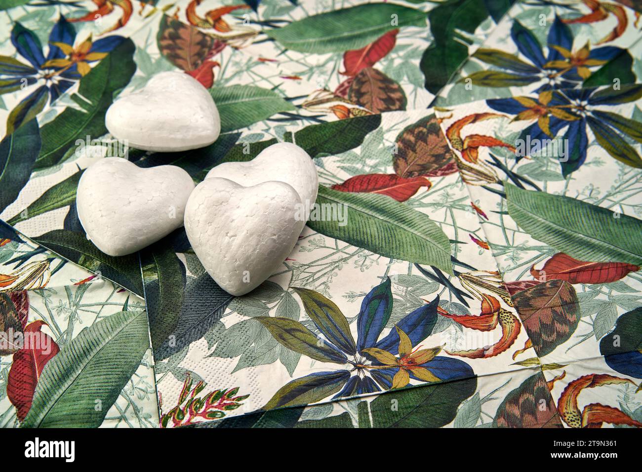 White hearts representing the purity of love on a tropical patterned ...