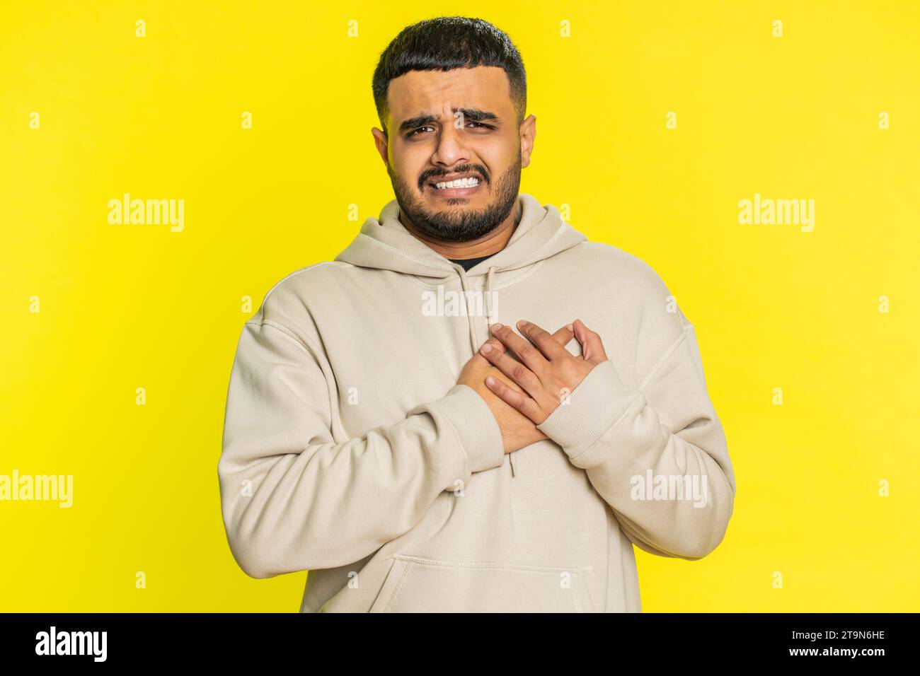 Stressed scared Indian man suffers from tension holding chest with ...