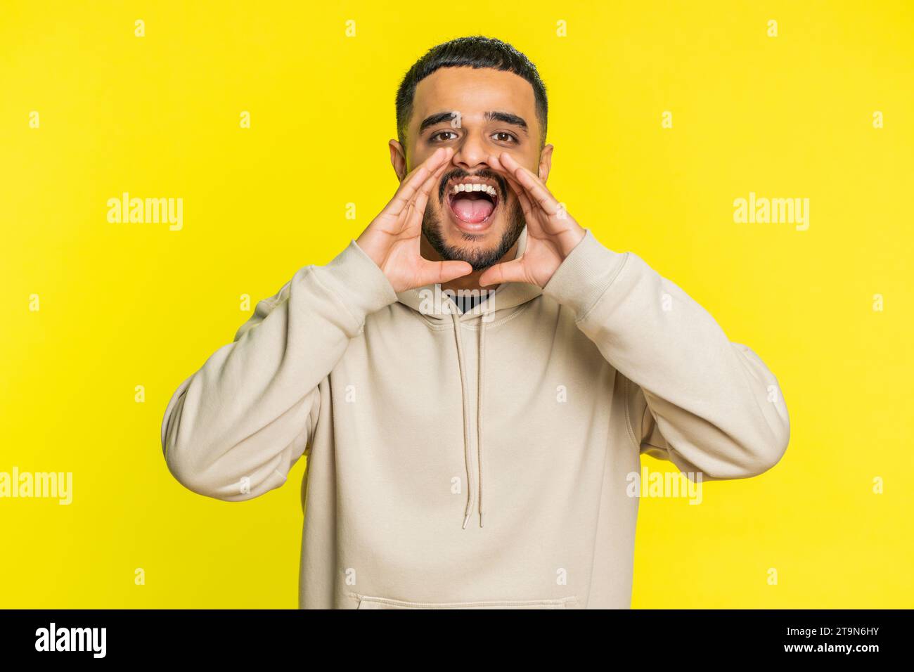 Happy Indian young man yell, shout to camera, promotion advertisement ...