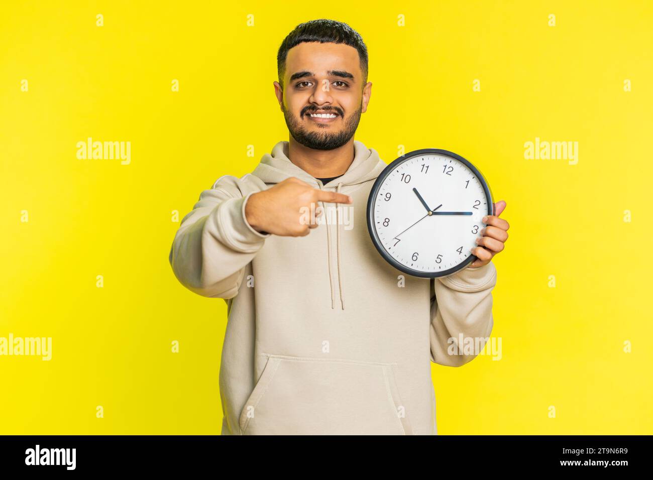 It is your time, hurry up. Indian Hindu man showing time on wall office ...