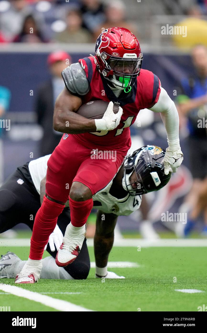 Houston Texans running back Dameon Pierce, front, evades a tackle ...