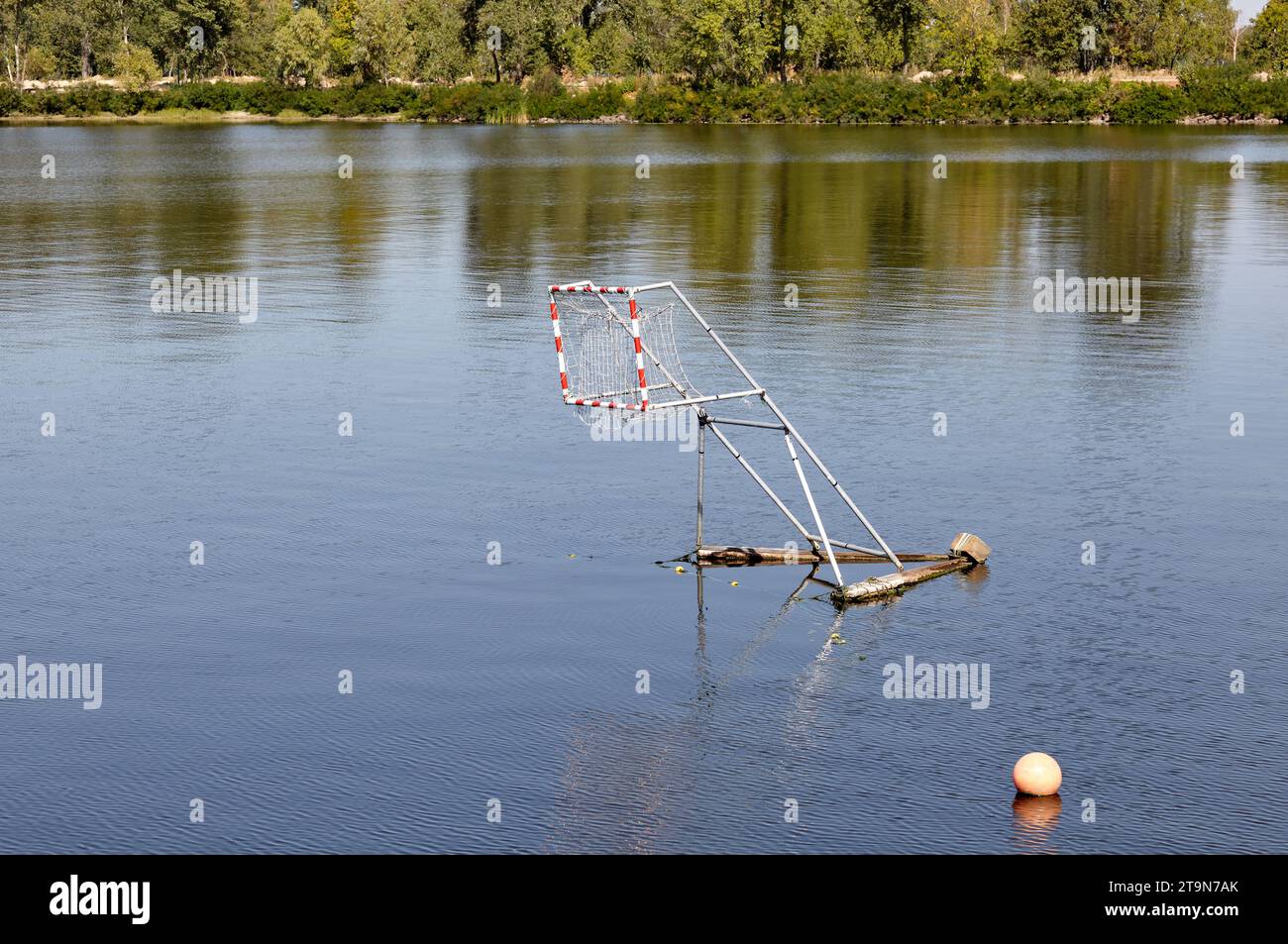 Water polo goal net and ball in water, outdoors. Leisure activity in ...