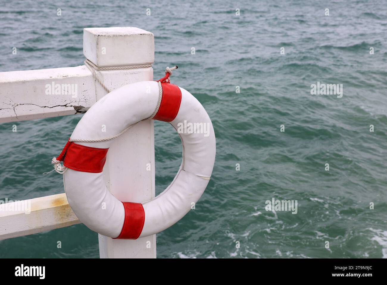 White lifebuoy on a beach. Safety on a water, life ring on storm sea ...