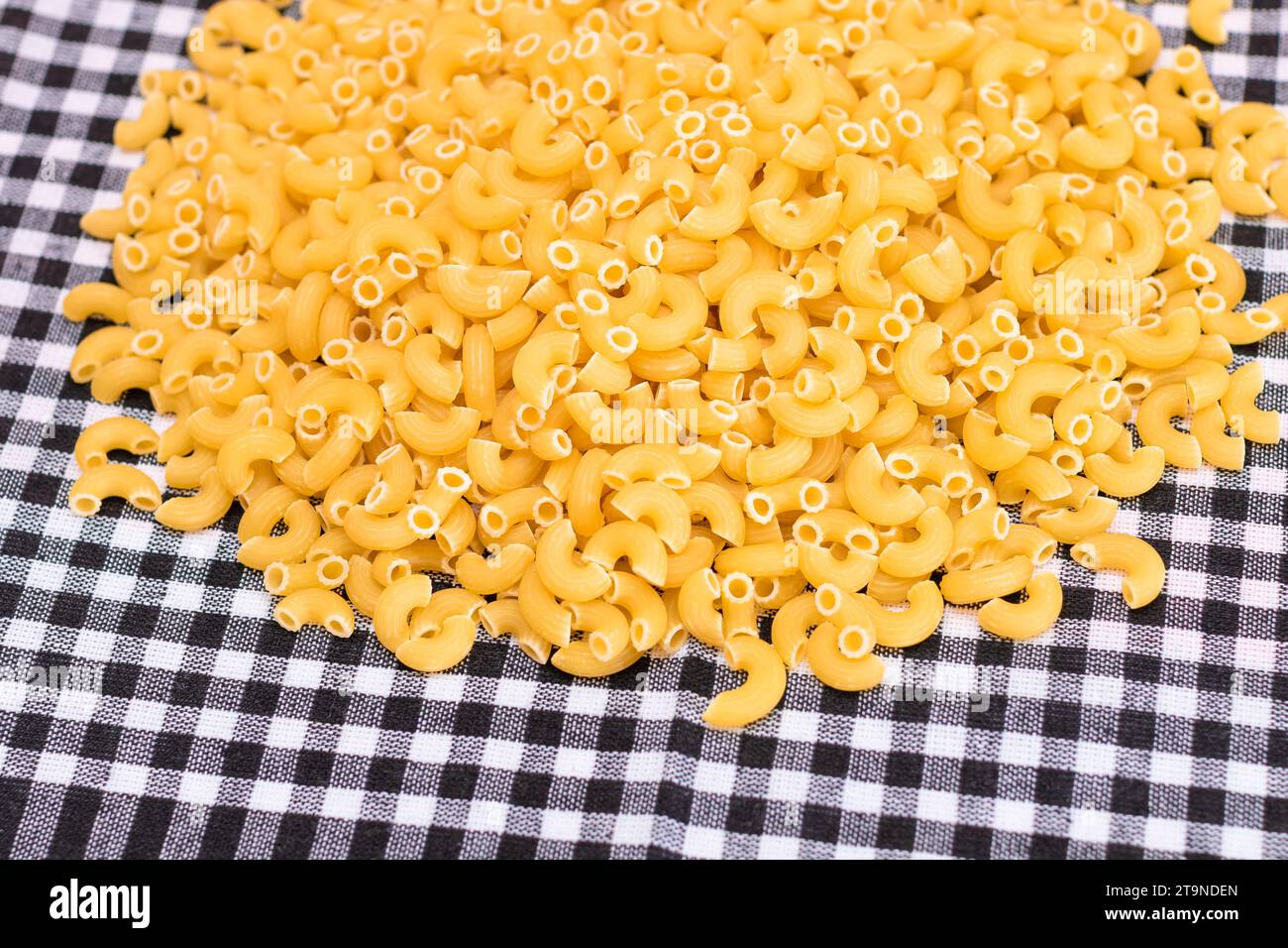 Scattered Uncooked Chifferi Rigati Pasta on Black Checkered Towel. Fat ...