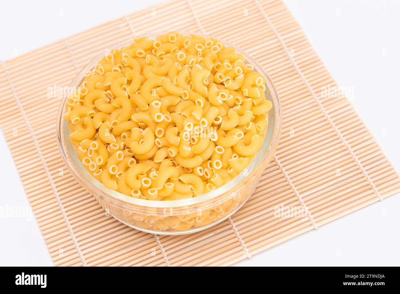 Uncooked Chifferi Rigati Pasta in Glass Jar on Bamboo Mat on White ...