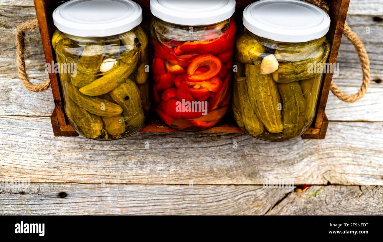 Glass jars with pickled red bell peppers and pickled cucumbers (pickles ...