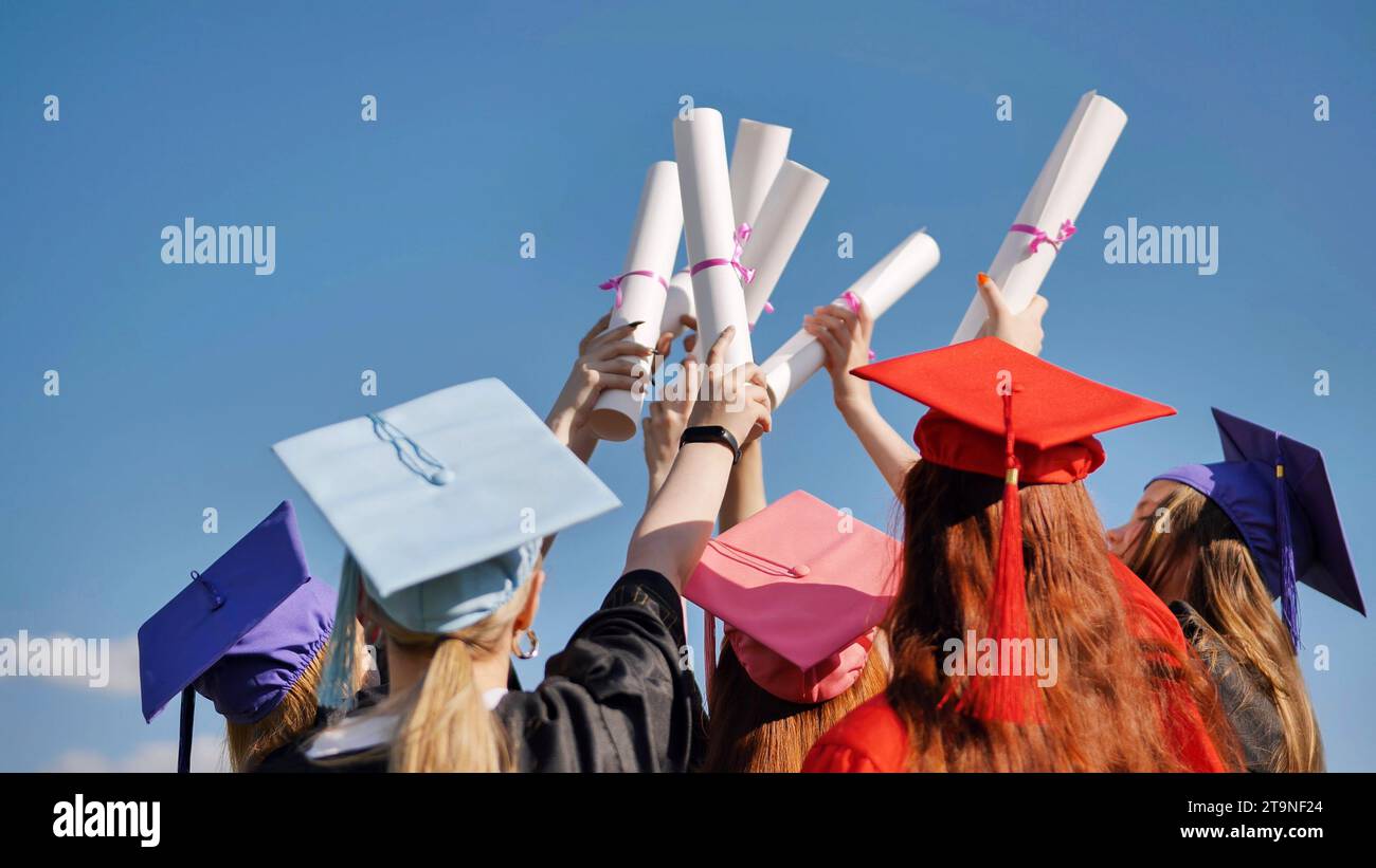College graduates with caps tie their diplomas together Stock Photo - Alamy
