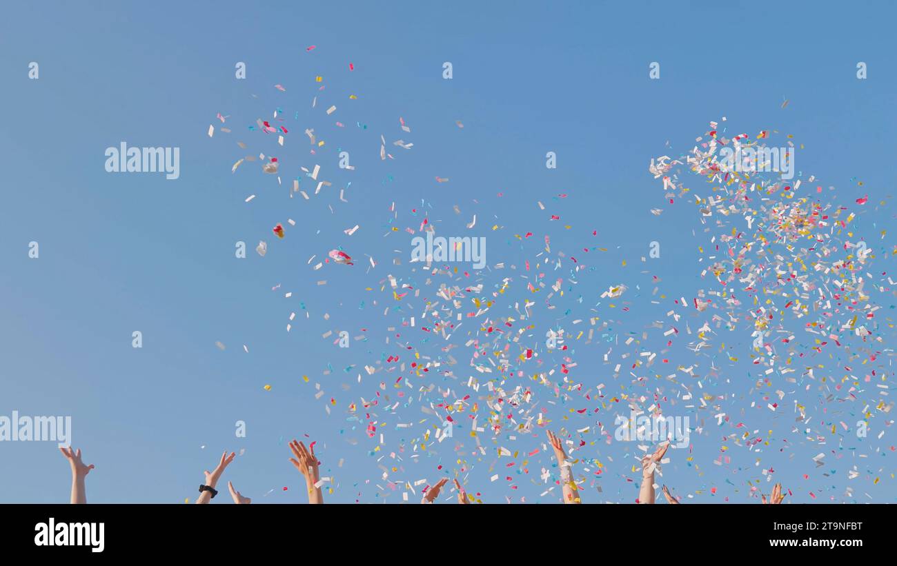 Tossing colorful paper confetti from the hands of young people Stock ...