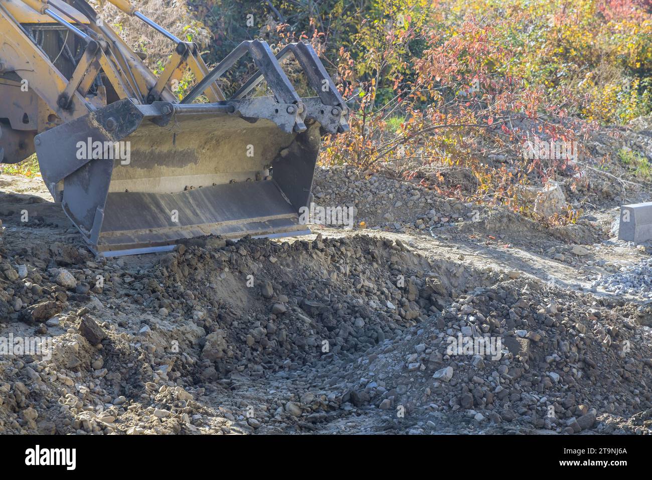 Construction excavator leveling ground for constructing roadwork ...