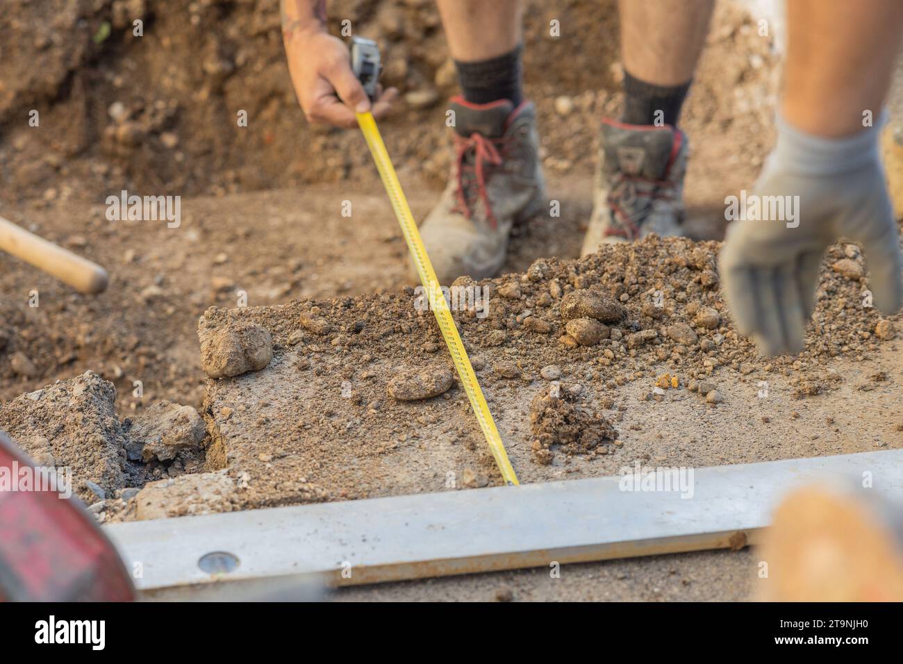 Man using a tape measure to calculate distance while making a hole in ... Man using a tape measure to calculate distance while making a hole in ...