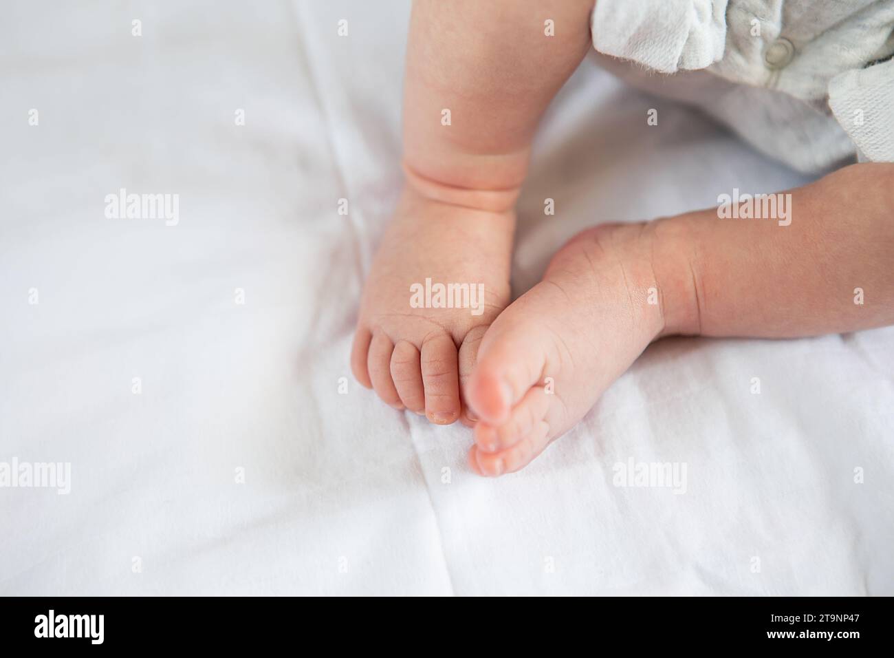 Small feet of a newborn baby on the bed, top view. The concept of ...