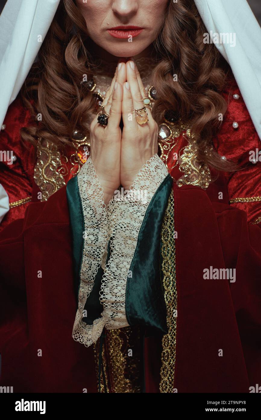 Closeup on medieval queen in red dress with veil praying Stock Photo ...