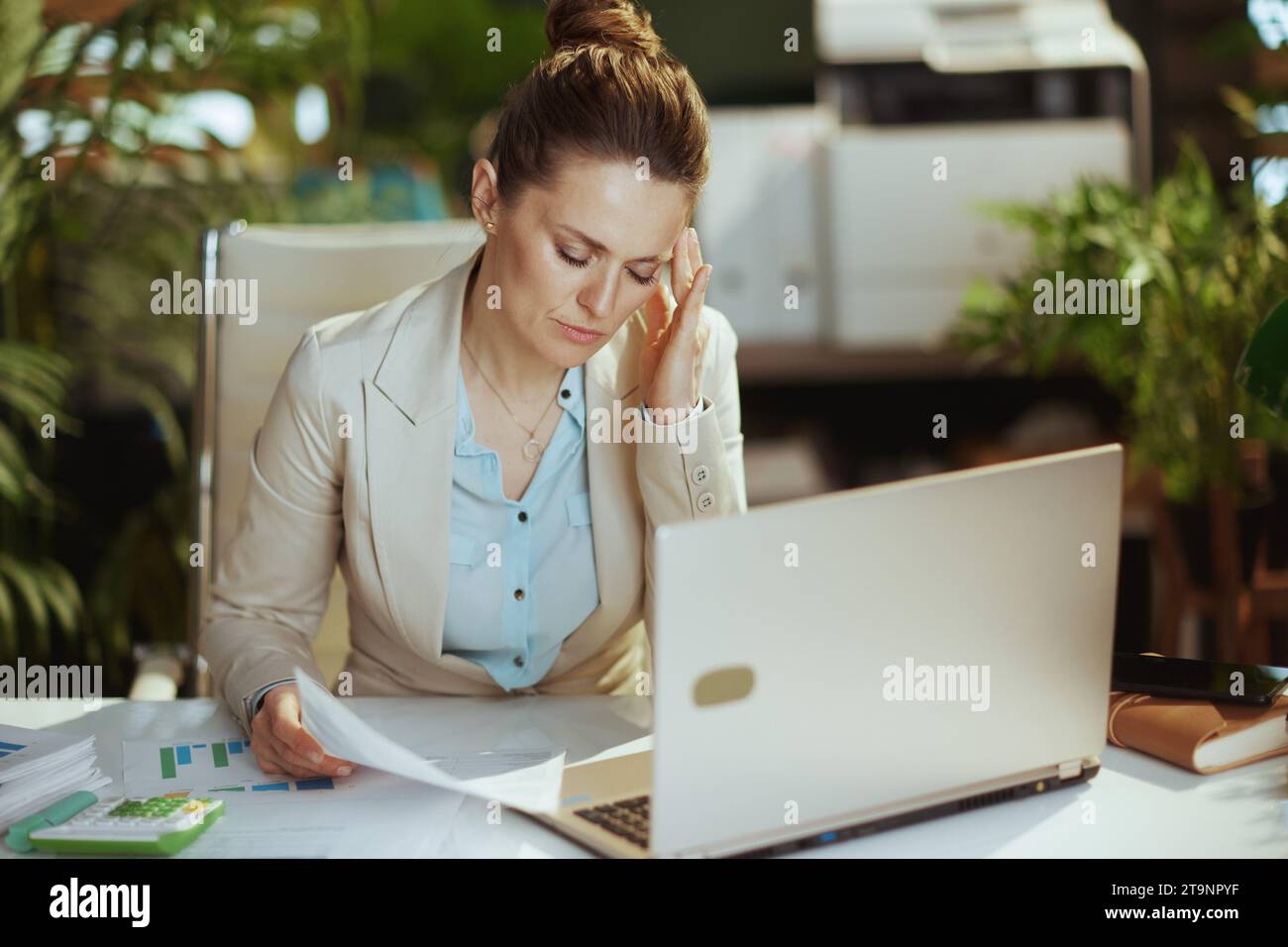 stressed modern middle aged bookkeeper woman in a light business suit ...