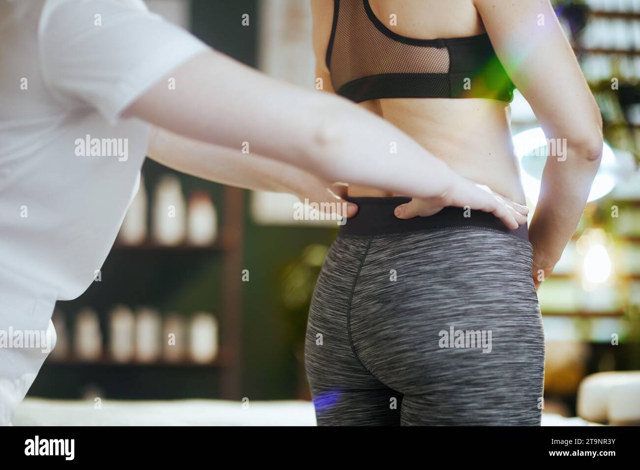 Healthcare time. Closeup on medical massage therapist in spa salon checking clients back ...