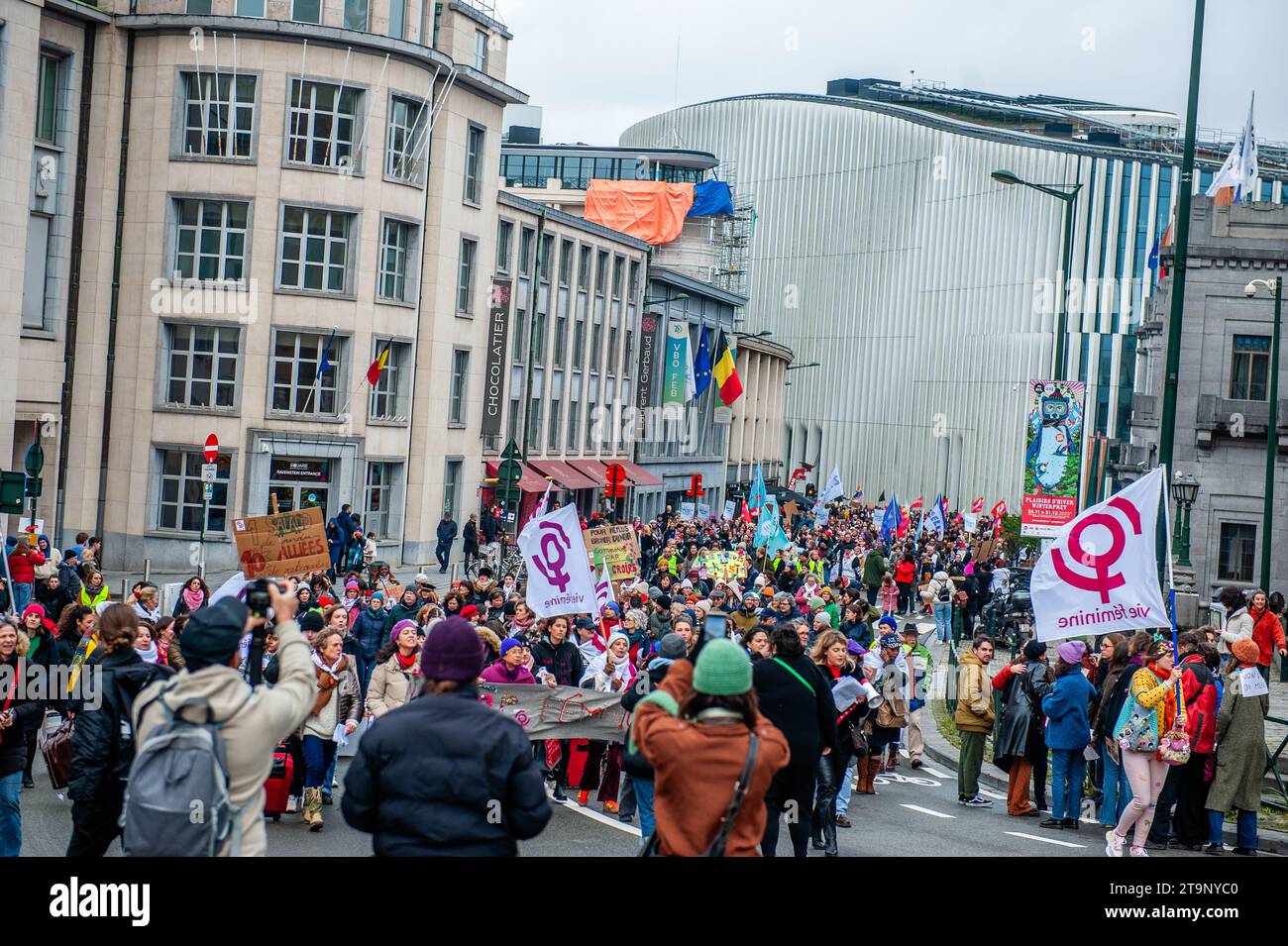 People are seen taking photos of the thousands of protesters marching ...