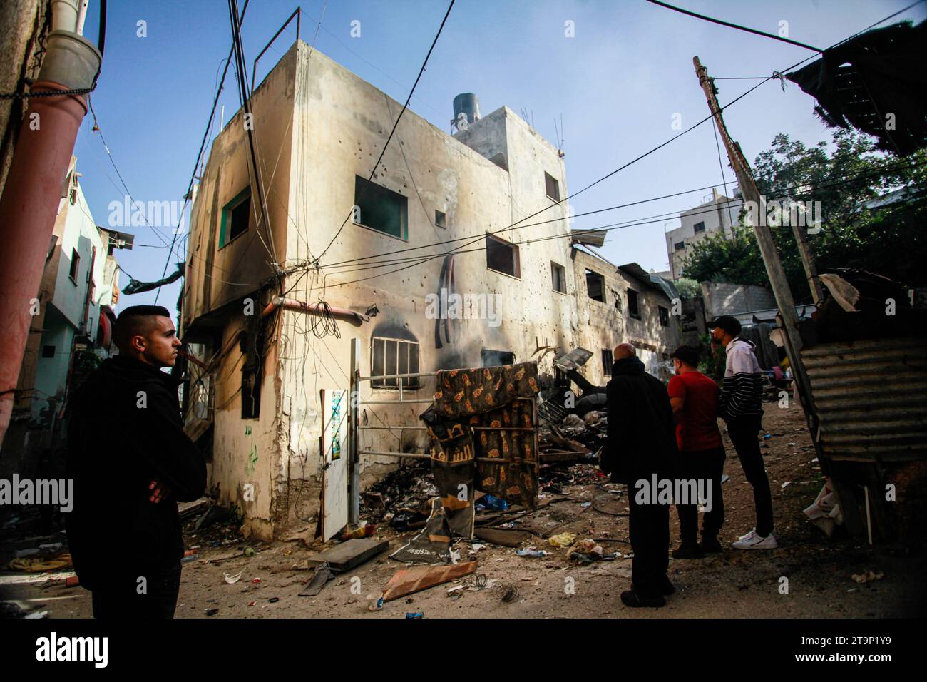 Jenin, Palestine. 26th Nov, 2023. People inspect damaged buildings ...
