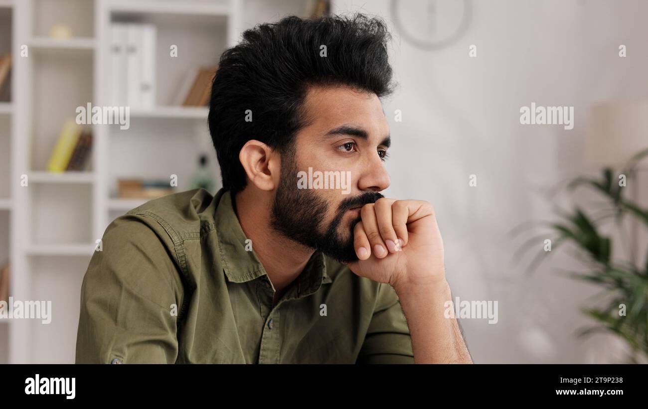 Bored millennial generation man sitting on sofa, feeling lonely at home ...