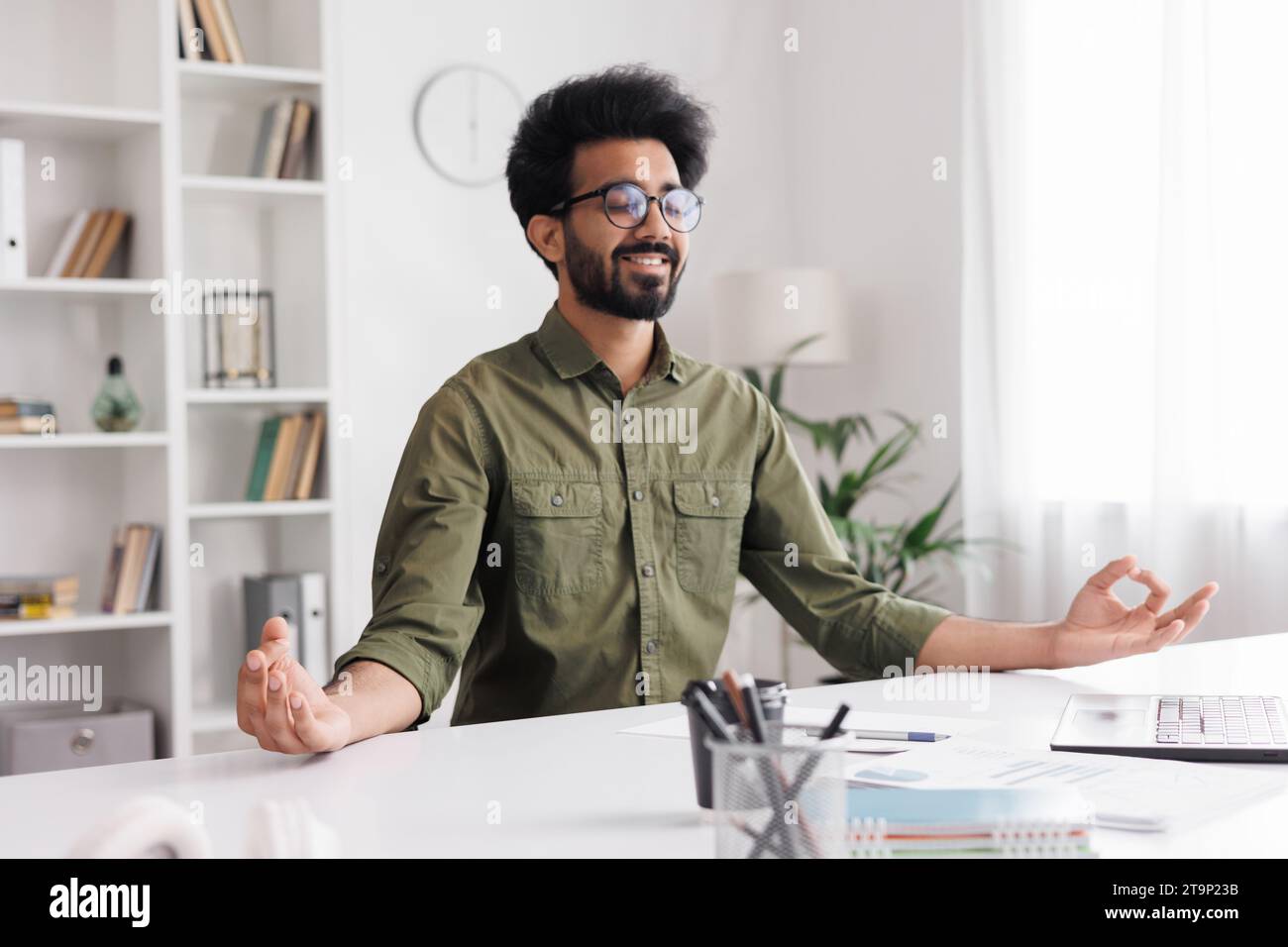 Managing stress in the workplace. Business man meditating and relaxing ...