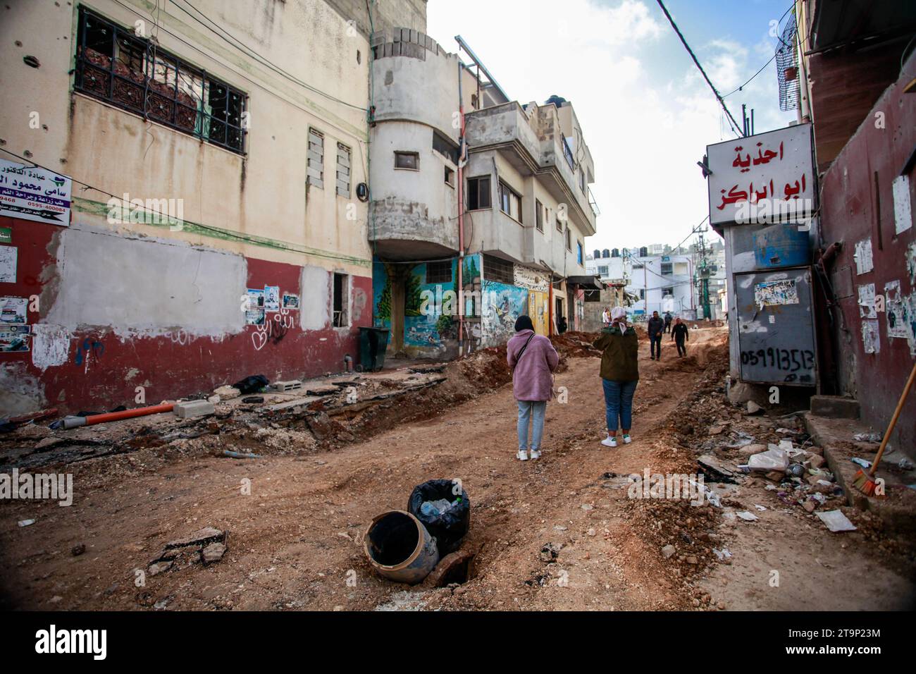 Jenin, Palestine. 26th Nov, 2023. People inspect damaged buildings ...