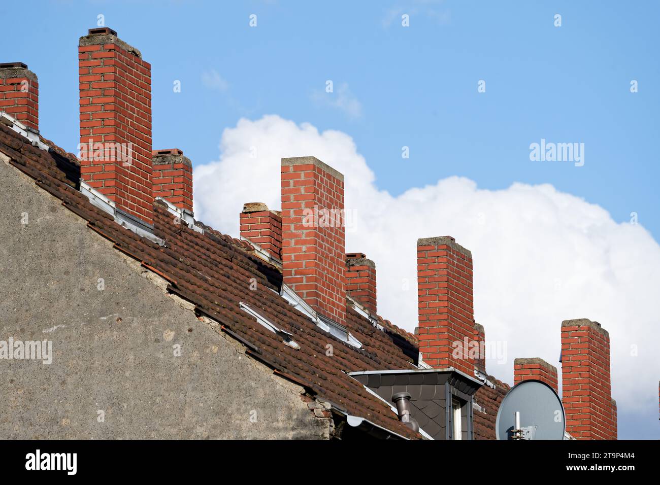 many brick chimneys on the roof of an old apartment building Stock ...