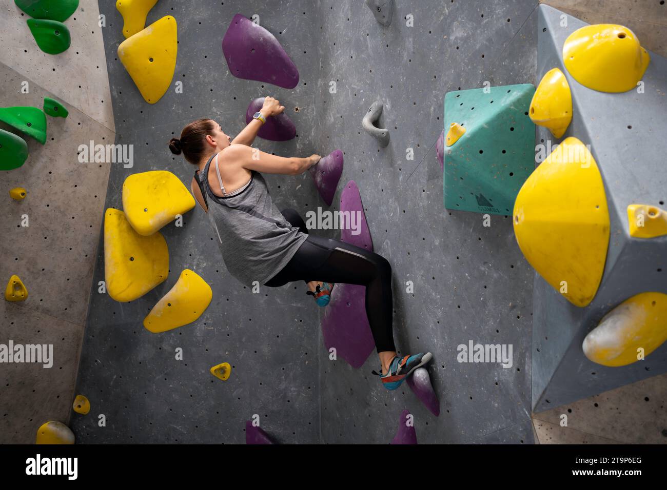 Mature woman climbs an exercise mountain at gym. Adult woman practicing ...