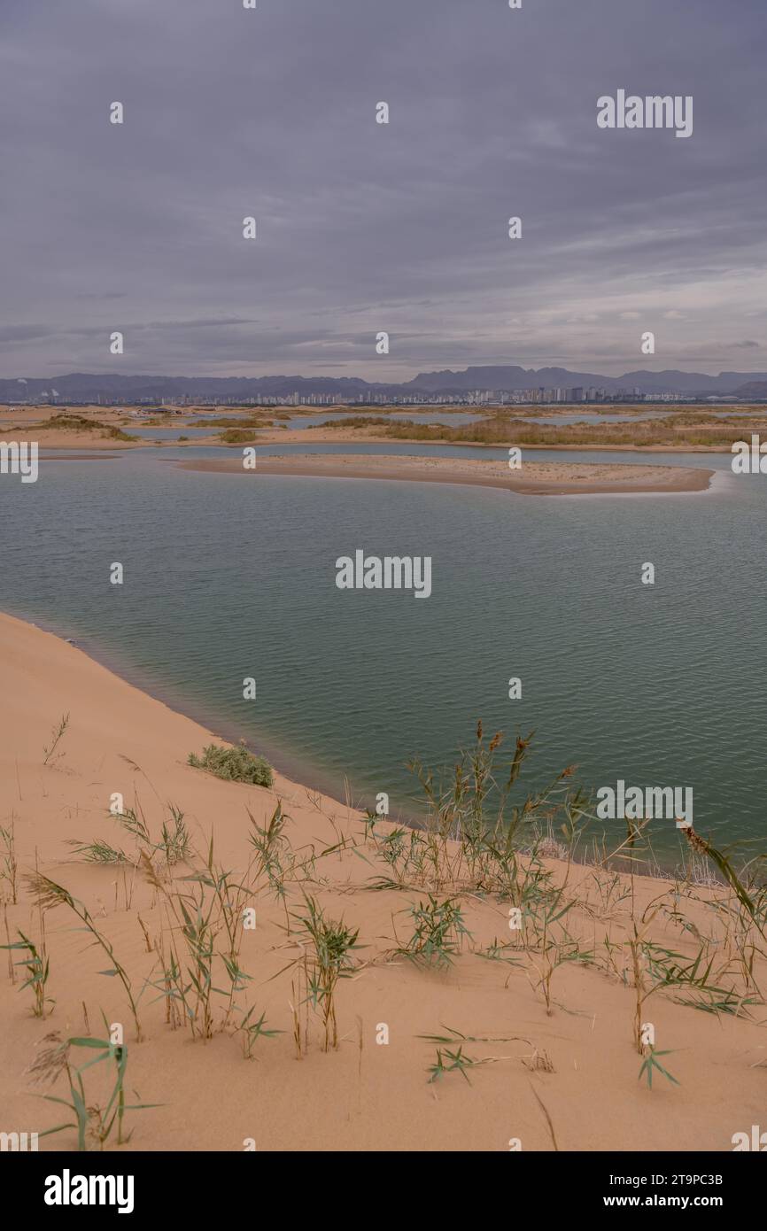 Desert vastness next to lake in Wuhai, Inner Mongolia, China. Dramatic ...