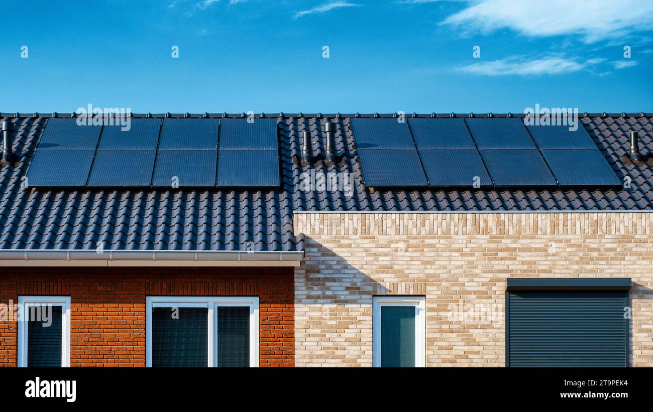 Newly built houses with black solar panels attached to the roof ...