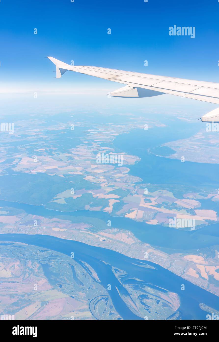 Aerial view from airplane window above green ground. View from the ...