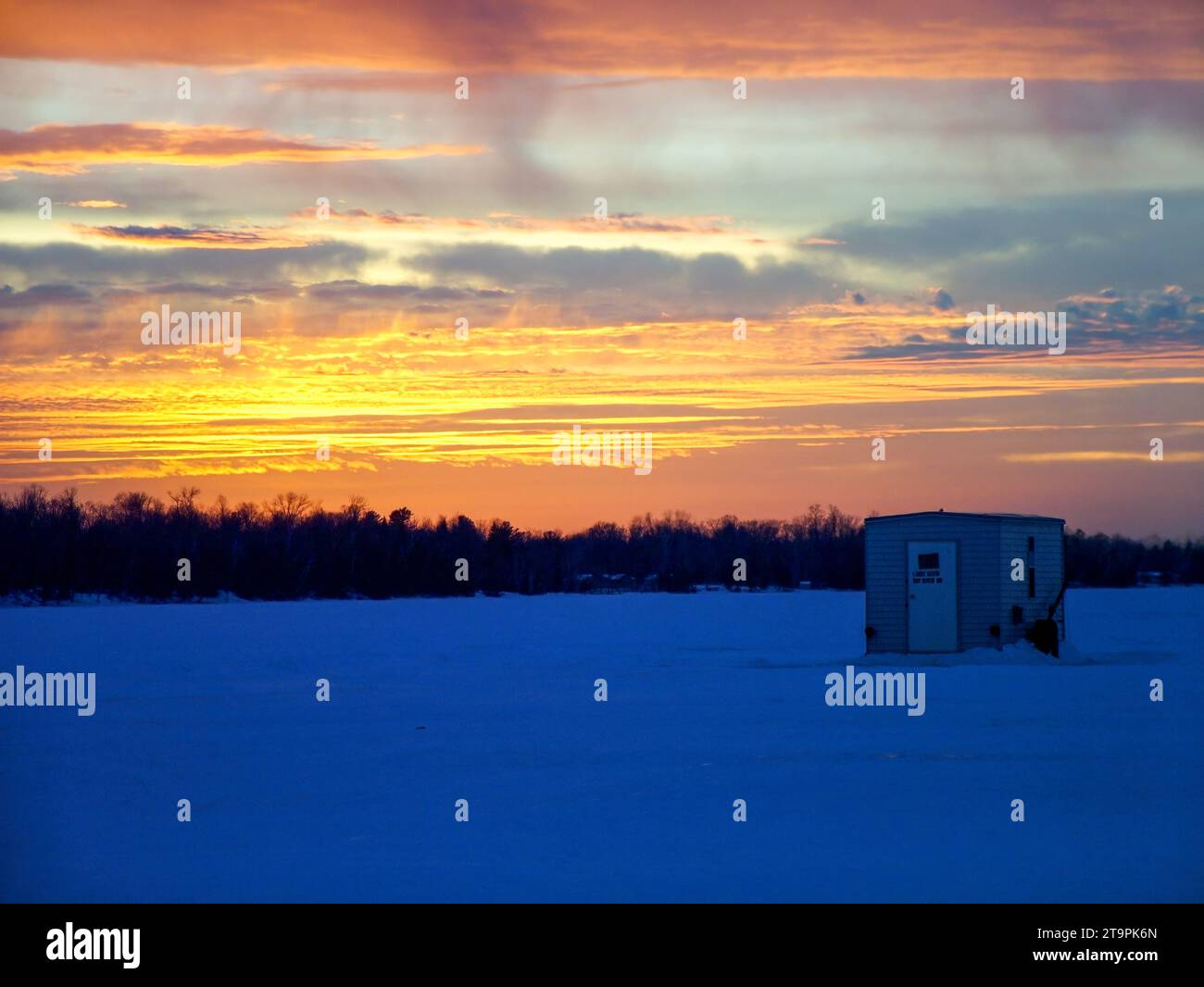 Colorful dusk/sunset on frozen northern Minnesota lake, with fish house ...