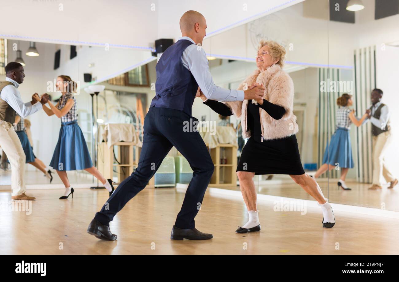 Mature woman dancing swing with young man Stock Photo - Alamy