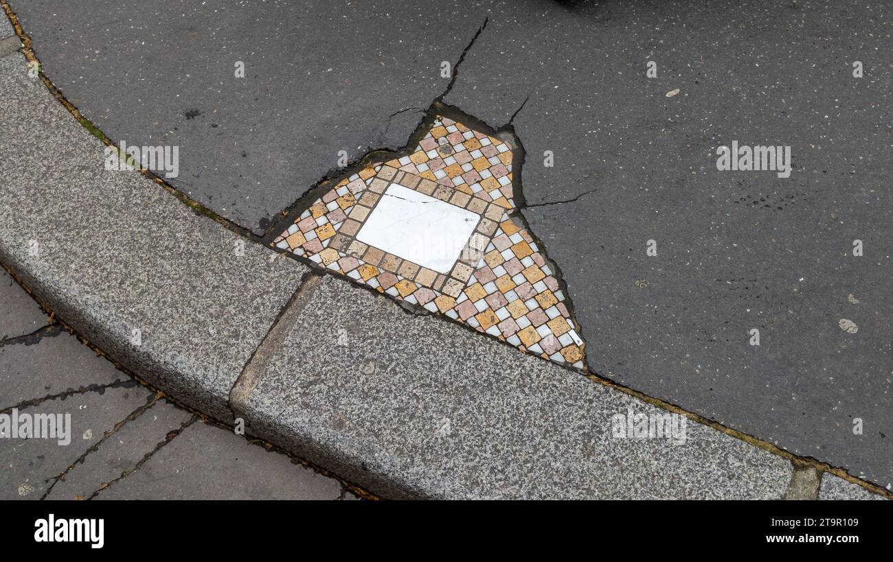 damaged and restored urban road sidewalk filled with tiles by an artist ...