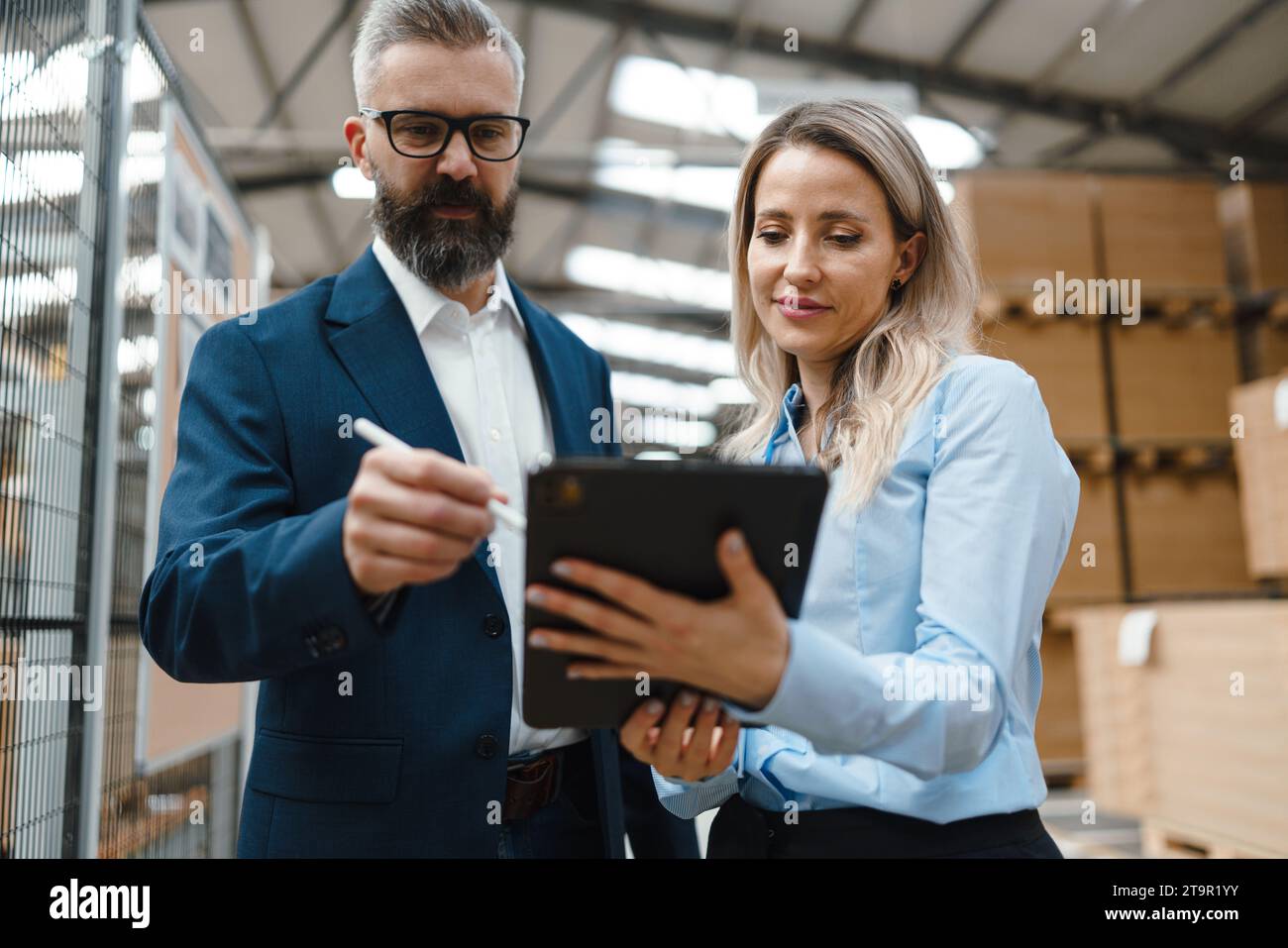 Female engineer and male project manager standing in modern industrial ...