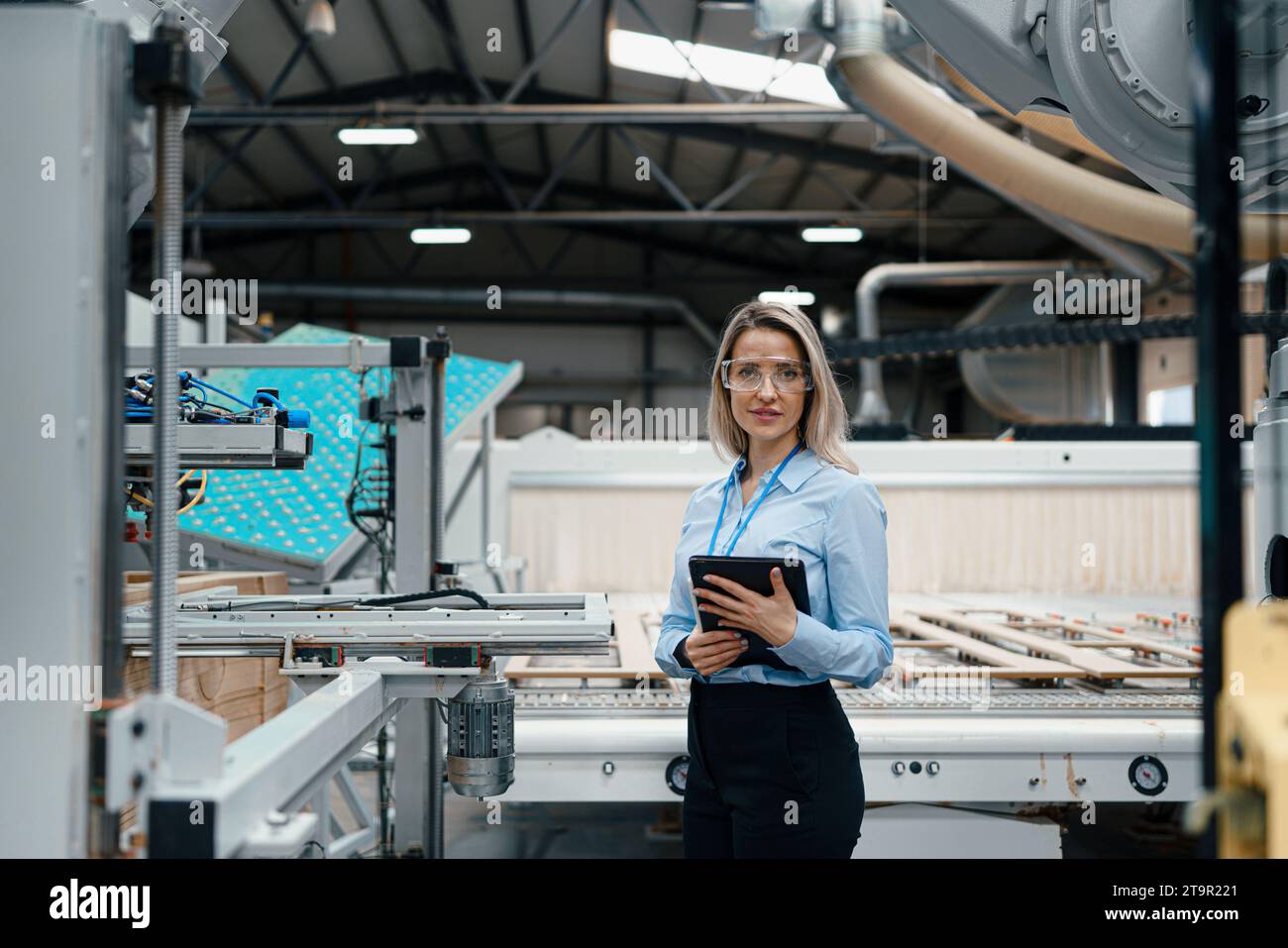 Female engineer standing in modern industrial factory. Manufacturing ...