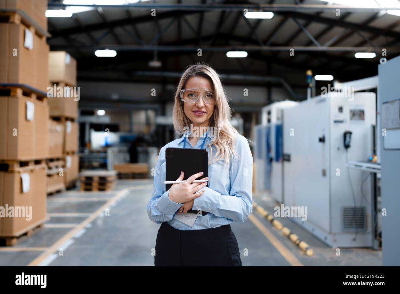 Female manager standing in modern industrial factory. Manufacturing ...