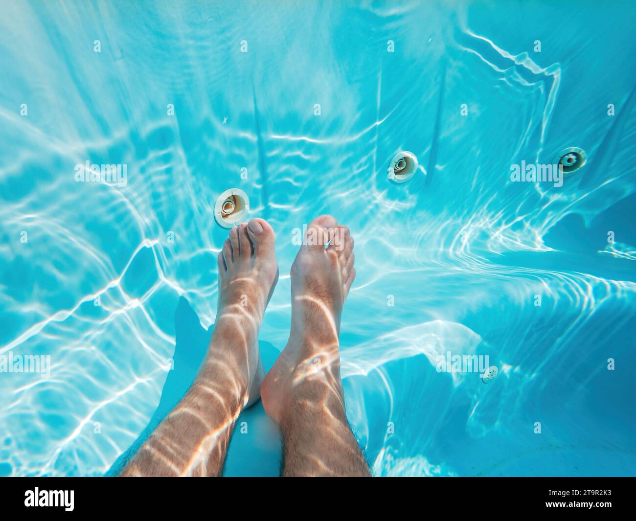 Jacuzzi hot tub, underwater shot of male legs in water, selective focus ...