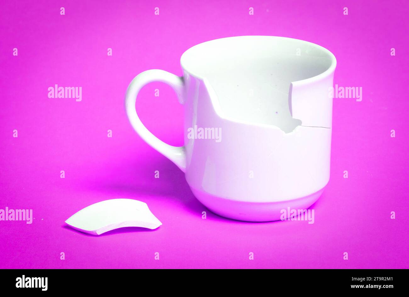Broken cup isolated on a solid pink background Stock Photo - Alamy