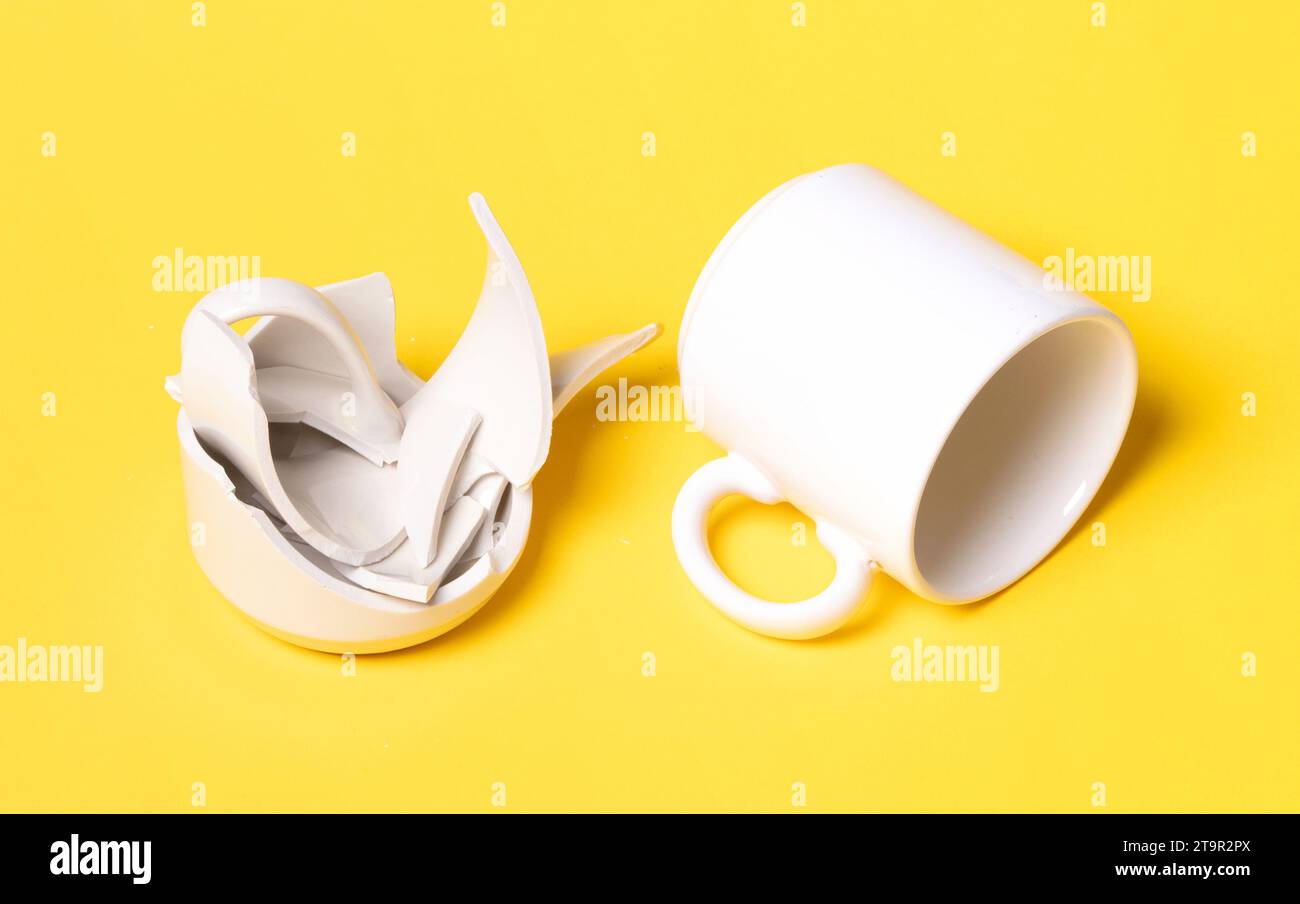 Broken cup isolated on a solid yellow background Stock Photo - Alamy
