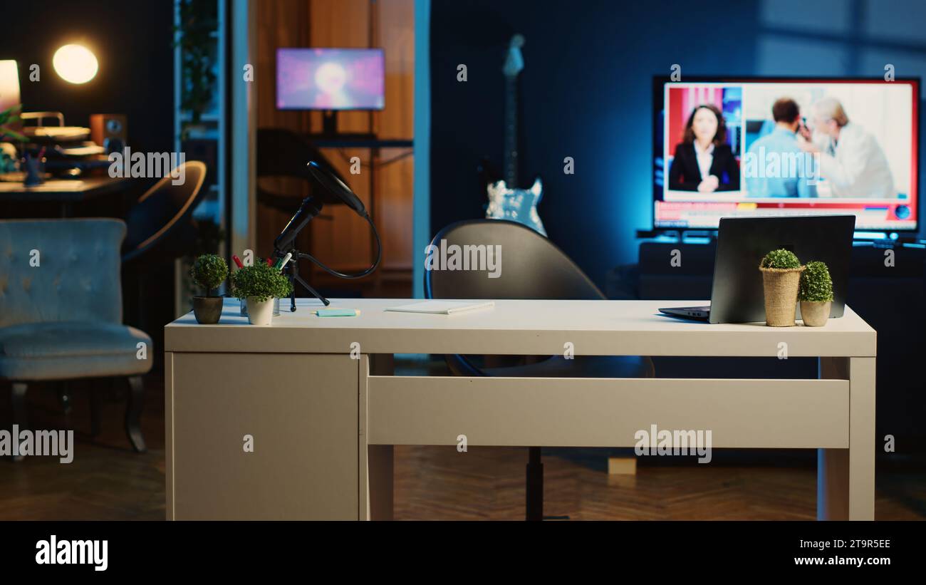 Panning shot of work desk with professional microphone and mini house ...
