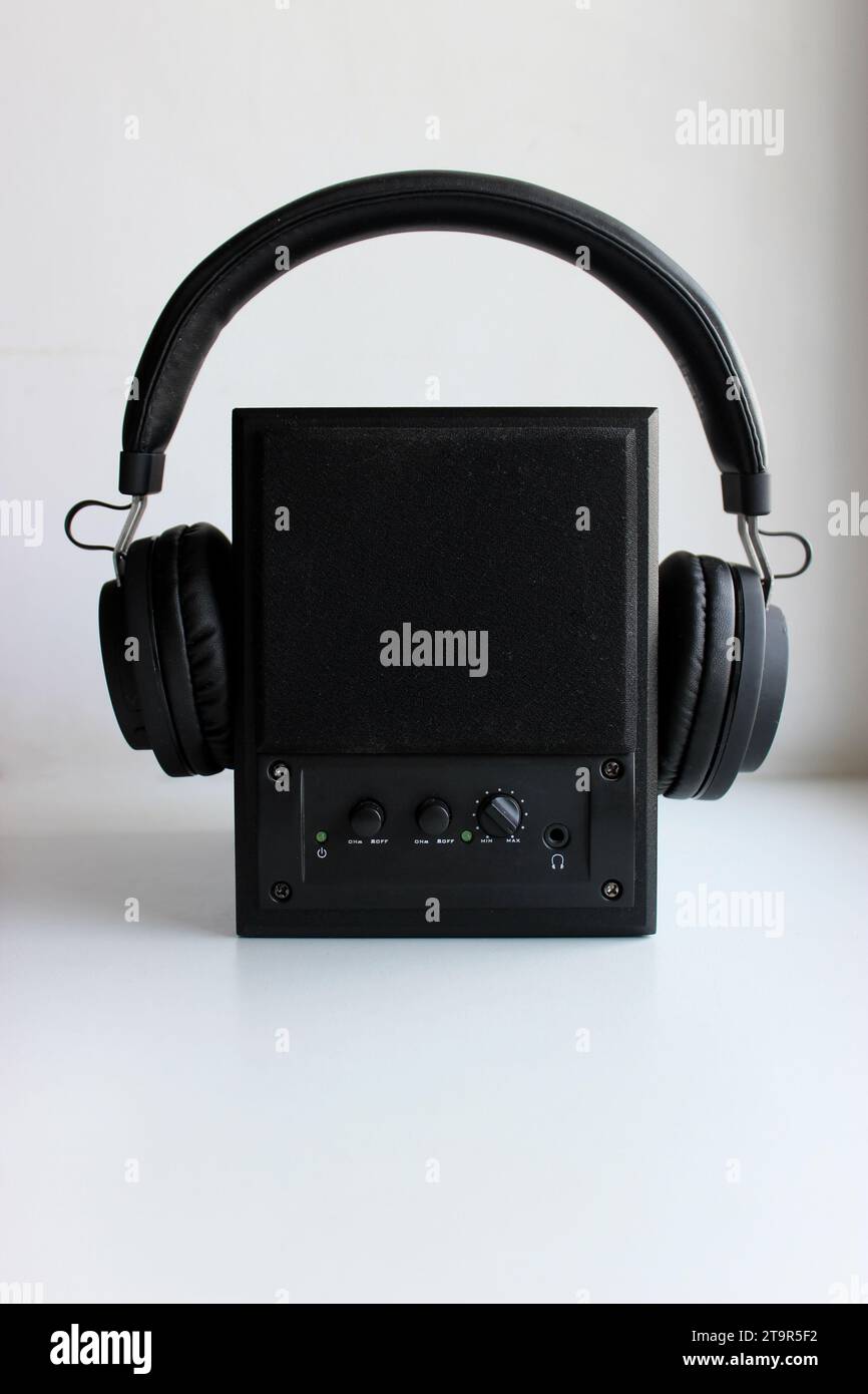 Black headphones on a black audio speaker front view Stock Photo - Alamy