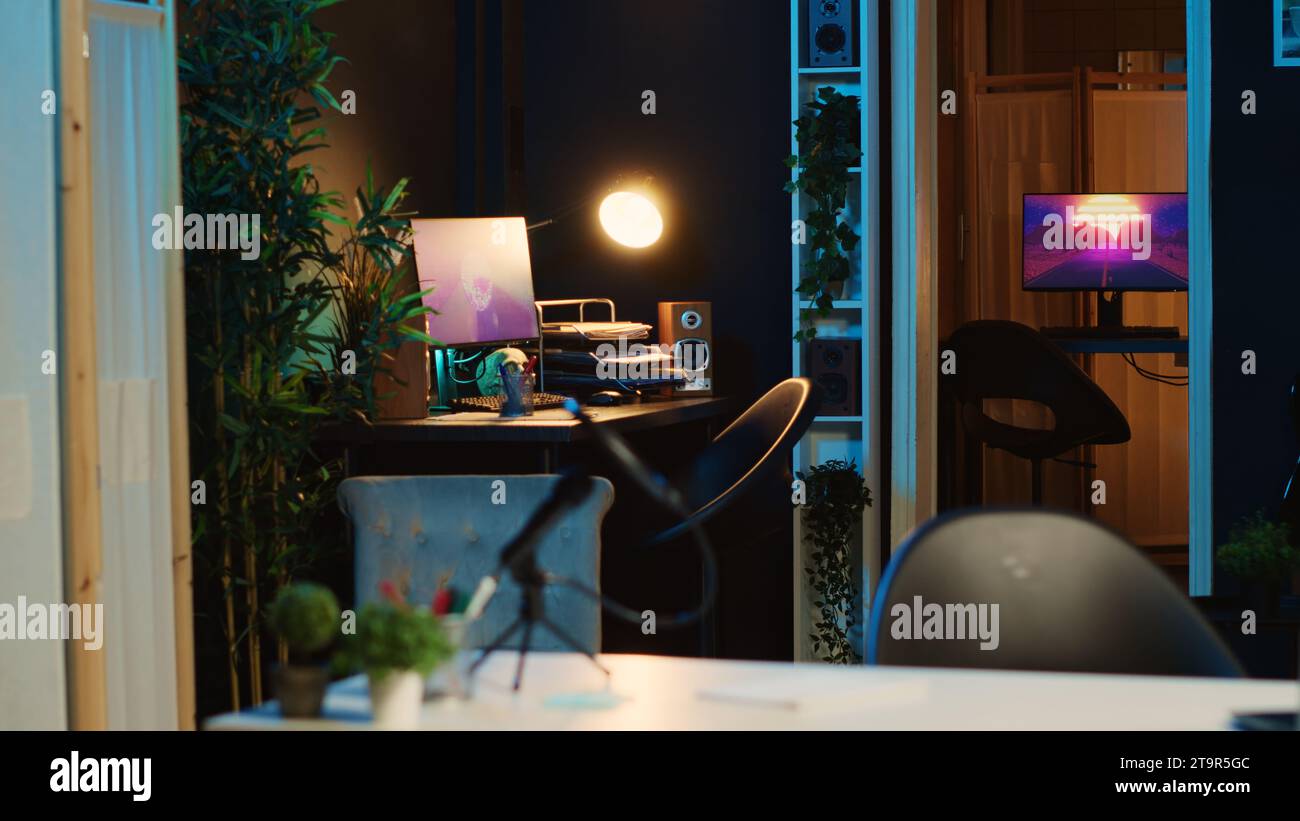 Computer screens showing running animation rendering in dimly lit empty ...