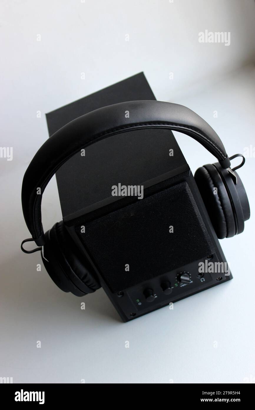 Plastic headphones put on a wooden loudspeaker on white surface Stock ...