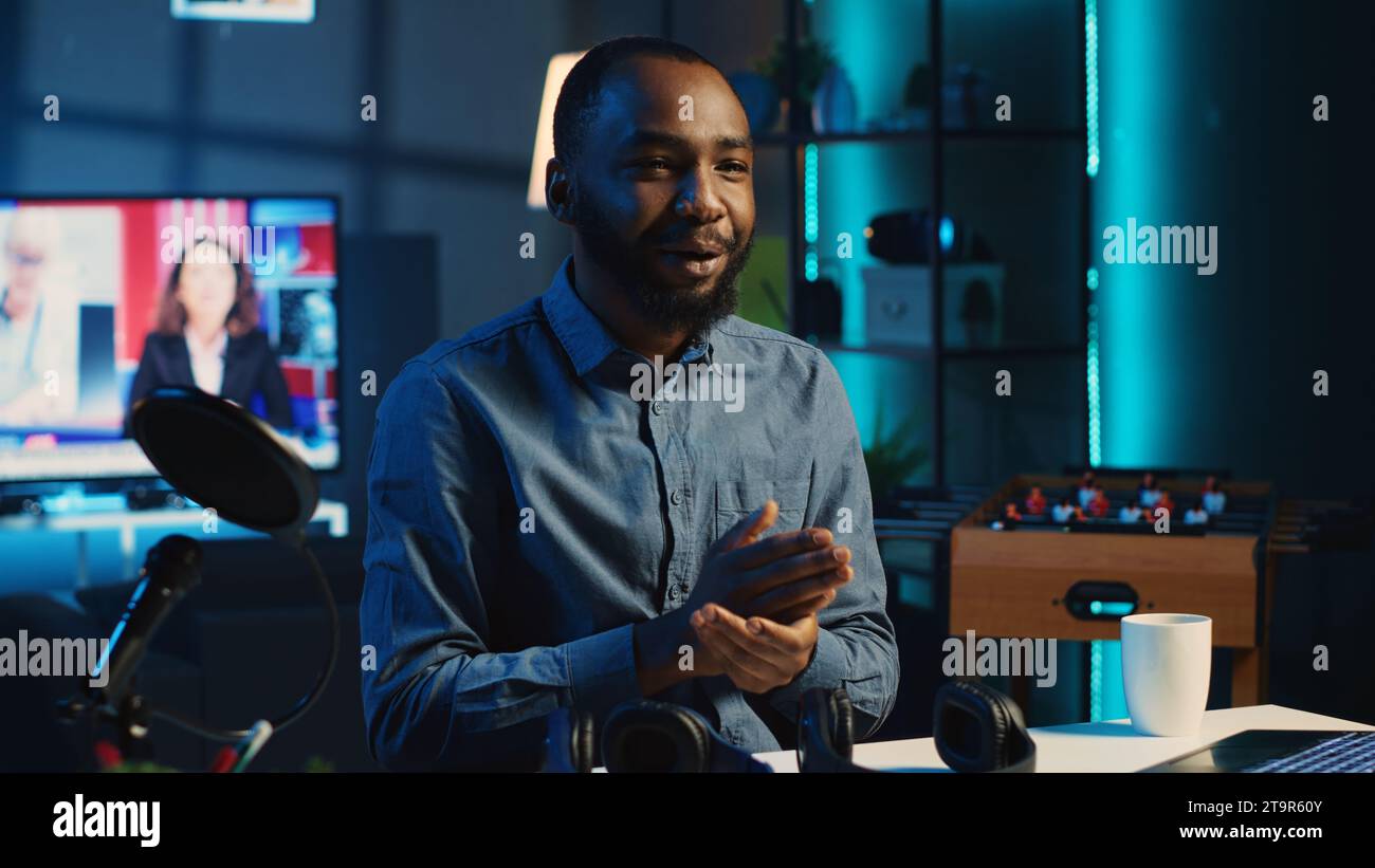 Content creator in dimly lit living room uses camera to film wireless ...
