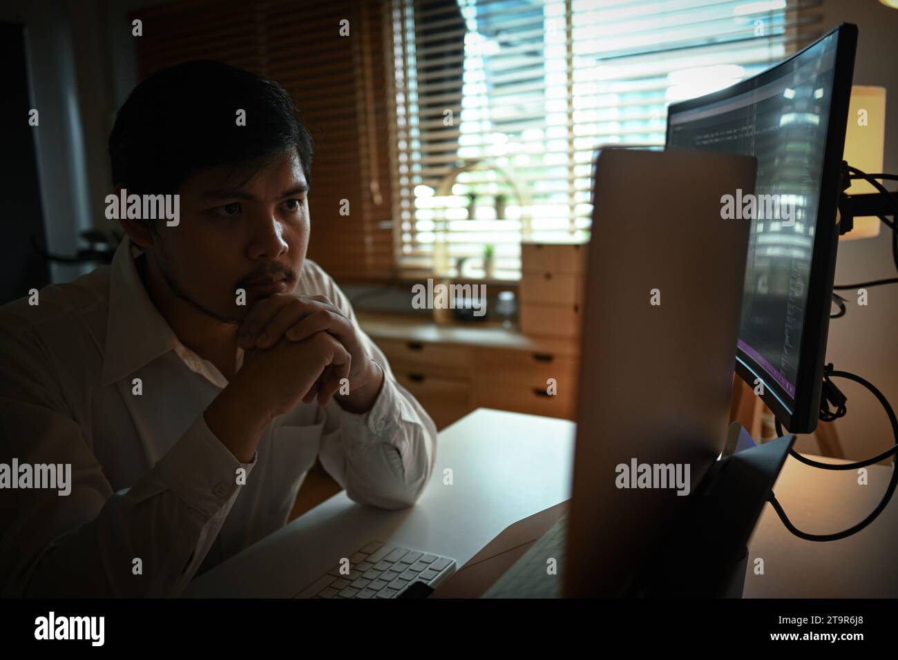 Concentrated male software developer programming code on the computer ...