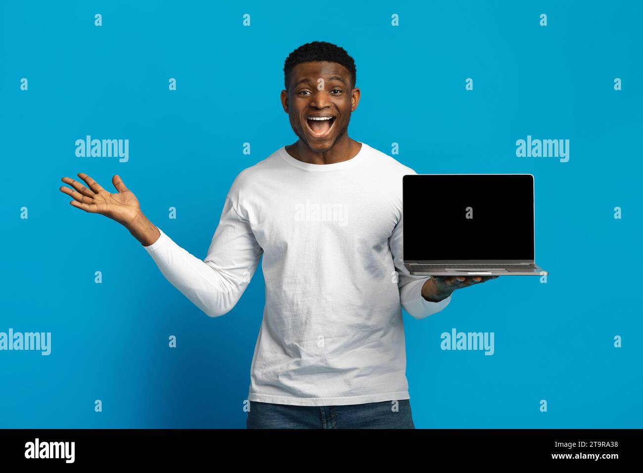 Excited young black guy showing laptop with blank screen Stock Photo ...