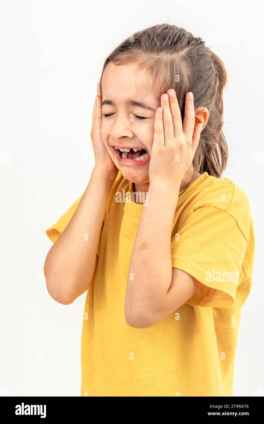 Little desperate girl looking panic, holding her head with both hands ...